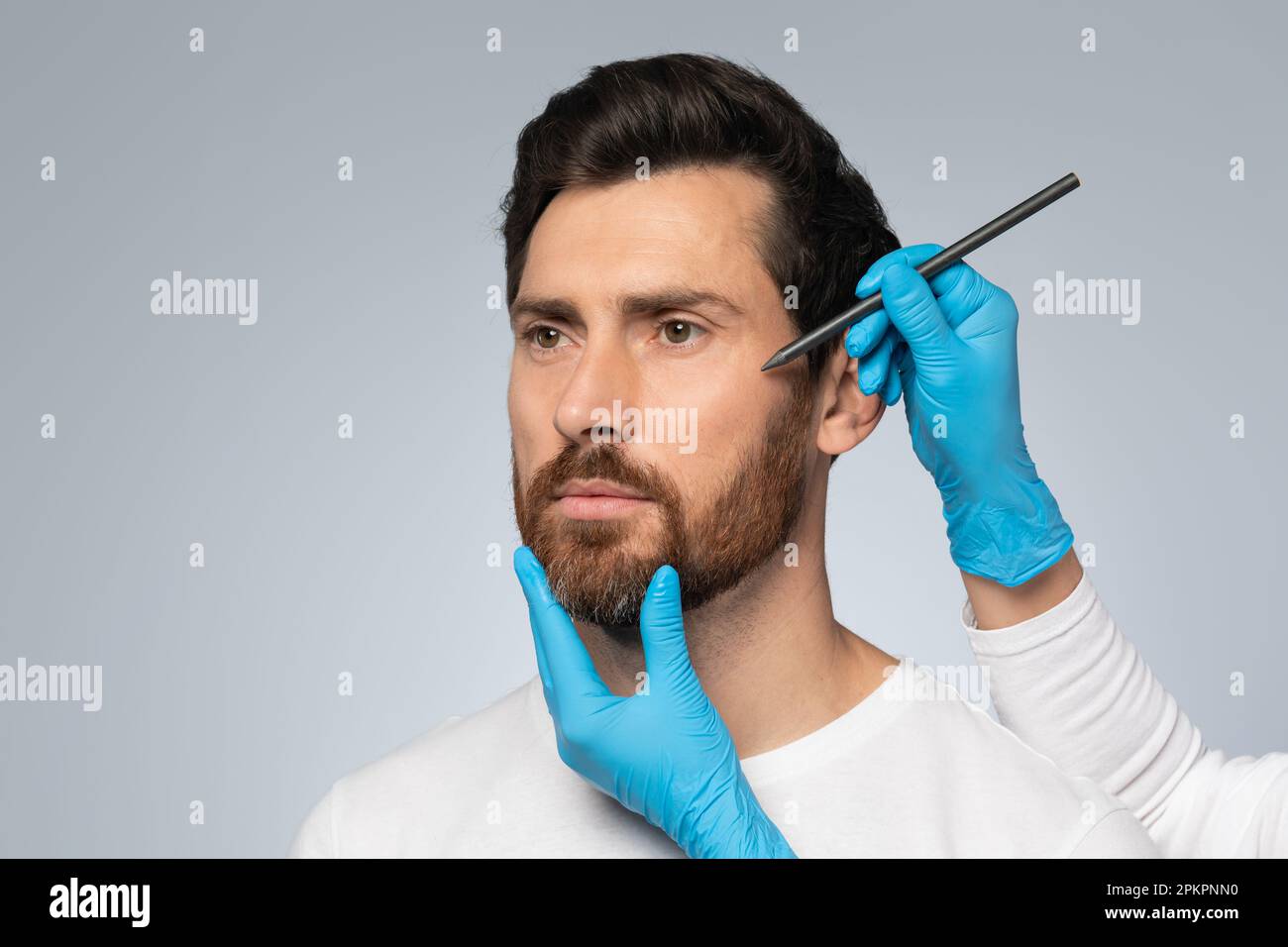 Hands of plastic surgeon in medical gloves drawing contours with black ...