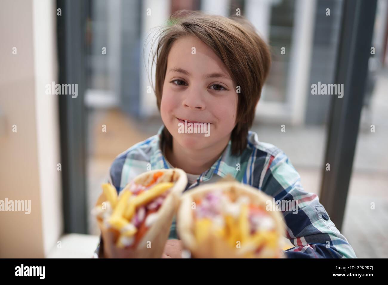 Happy little boy in a fast food restaurant. Portrait of cheerful white ...
