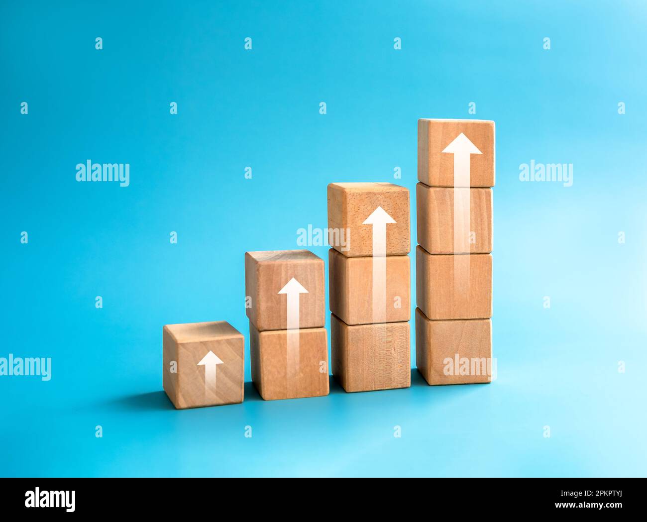 Rising up arrows shining on wooden cube blocks bar graph chart steps on ...