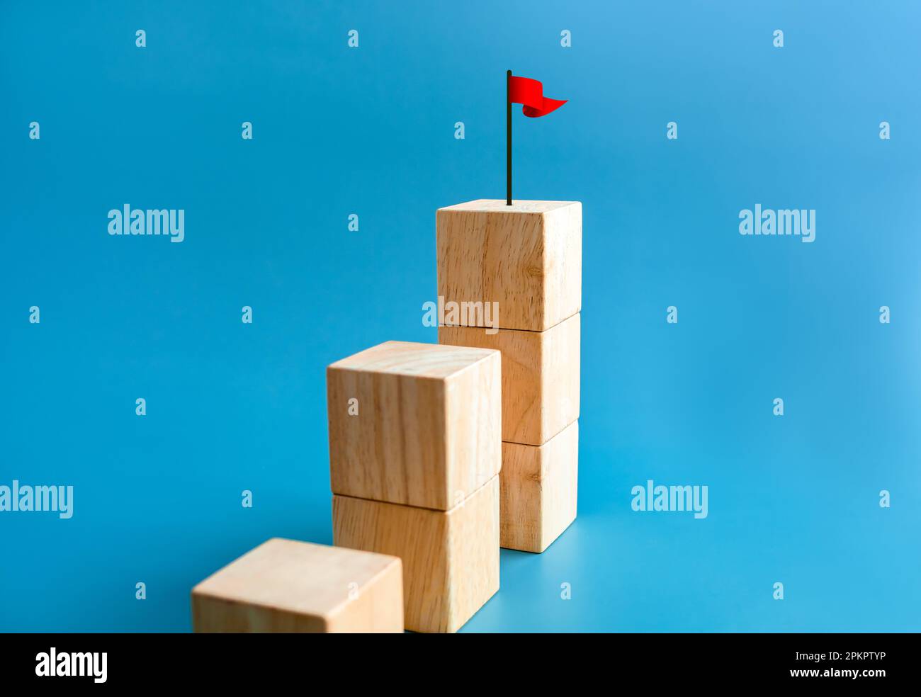 Goal and success. Red flag on the top of wooden cube blocks stacked ...