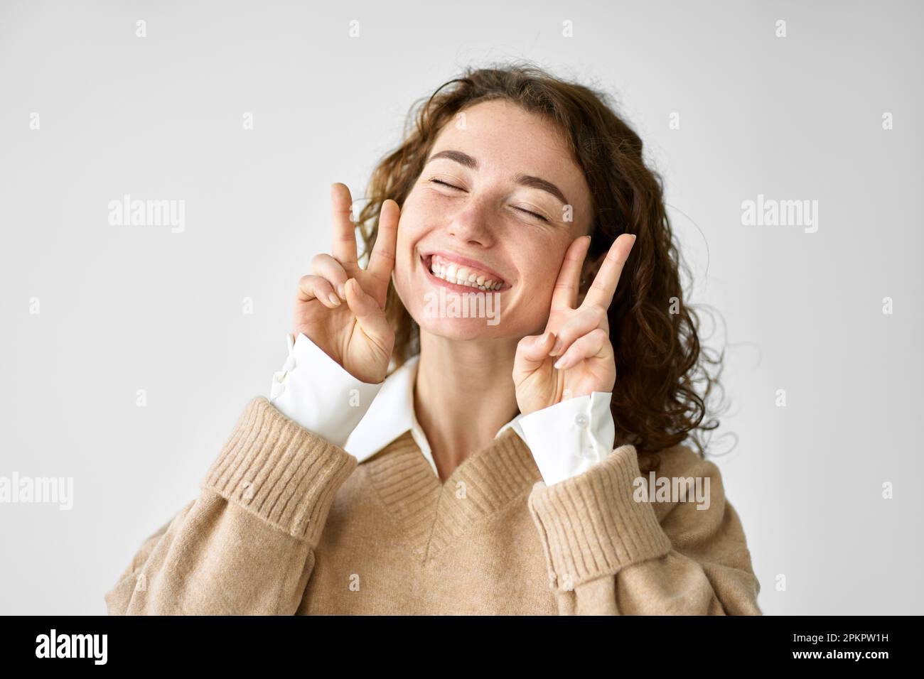 Happy pretty young woman model showing victory hand gesture isolated on ...