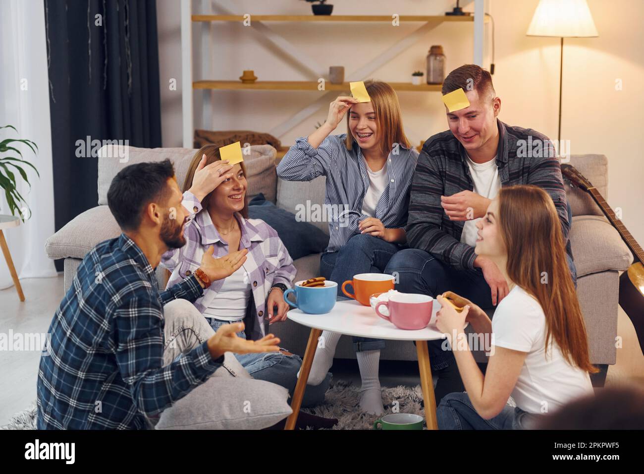 Playing who am I game. Group of friends have party indoors together ...