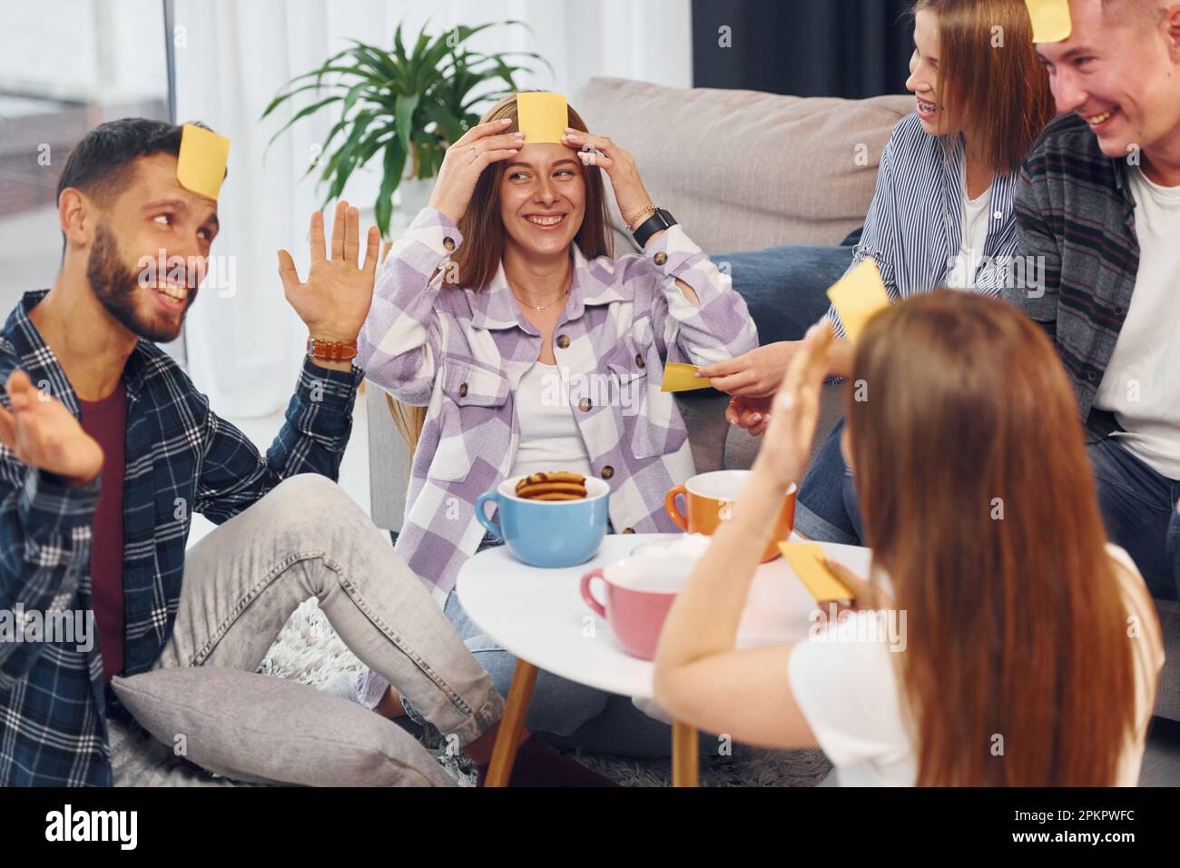 Playing who am I game. Group of friends have party indoors together ...