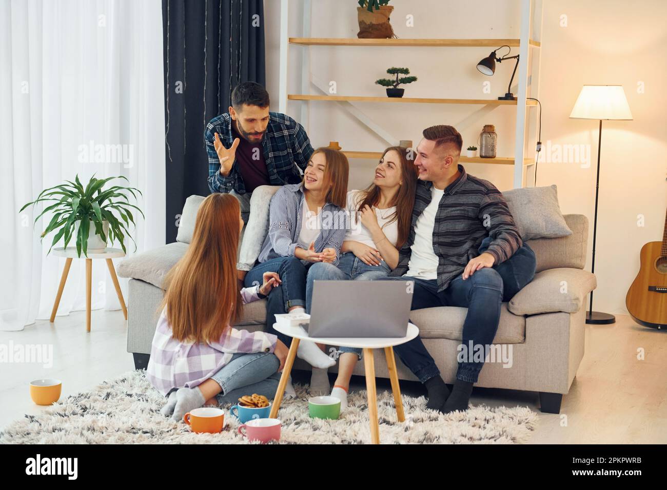 Using laptop. Group of friends have party indoors together Stock Photo ...