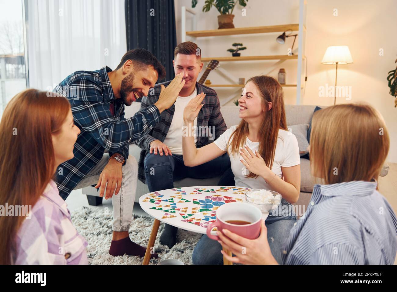 Playing smart game. Group of friends have party indoors together Stock ...
