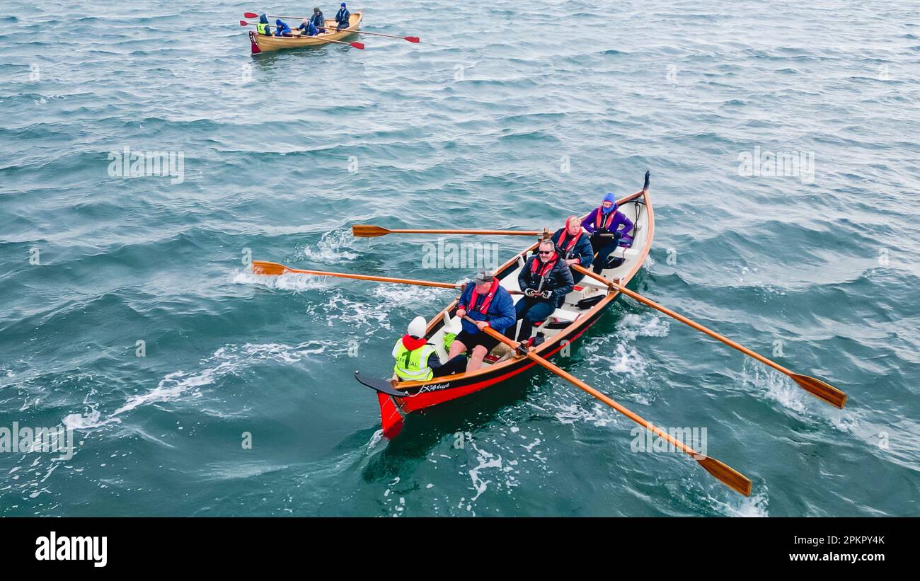 Rowers on a traditional wooden skiff rowing boat take part in a race ...