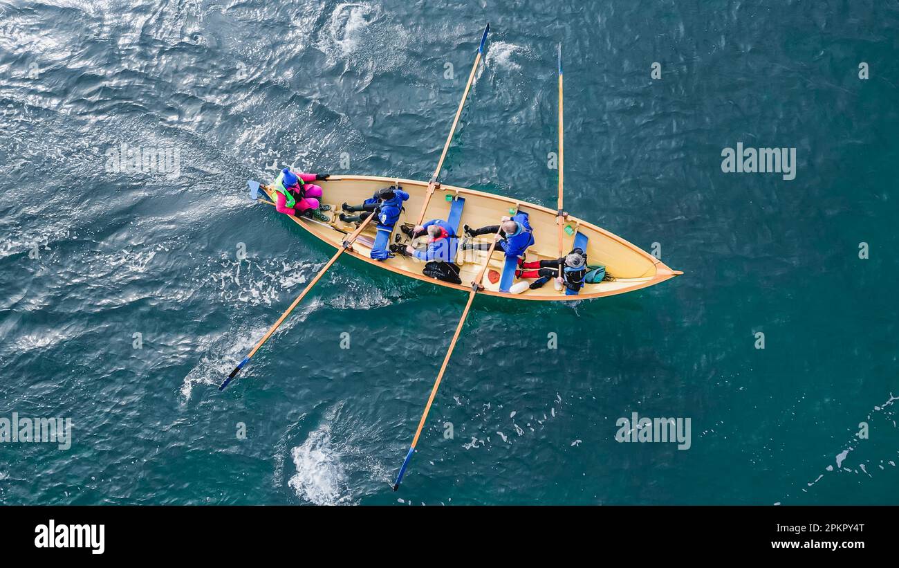 Rowers on a traditional wooden skiff rowing boat take part in a race ...