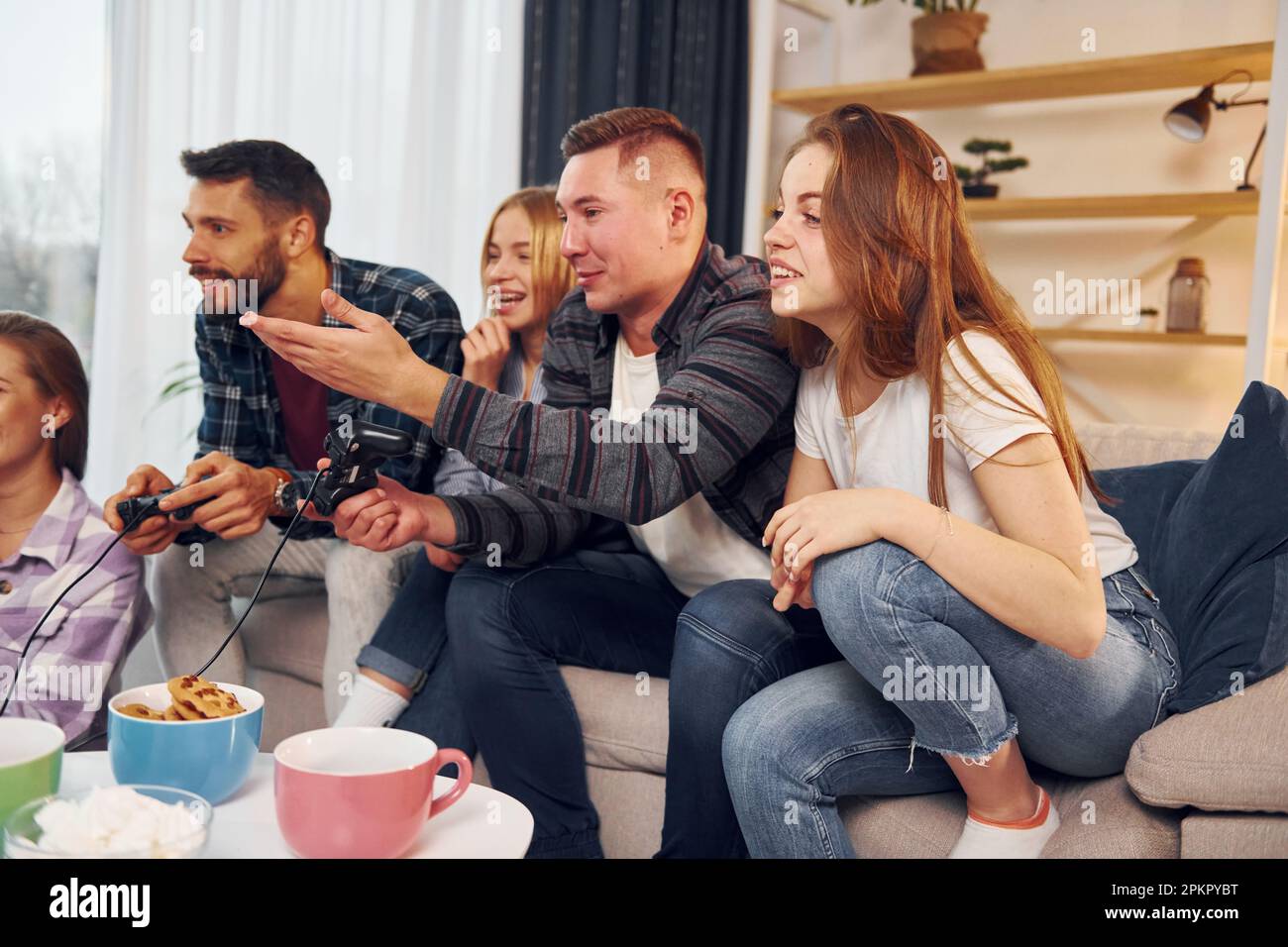 Playing video game. Group of friends have party indoors together Stock ...