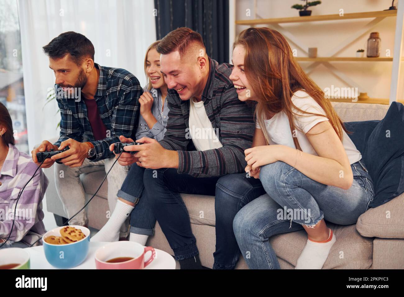 Free time entertainment. Group of friends have party indoors together ...