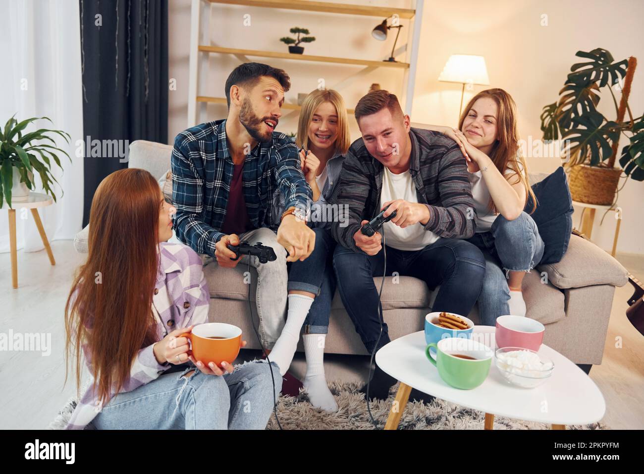 Playing video game. Group of friends have party indoors together Stock ...