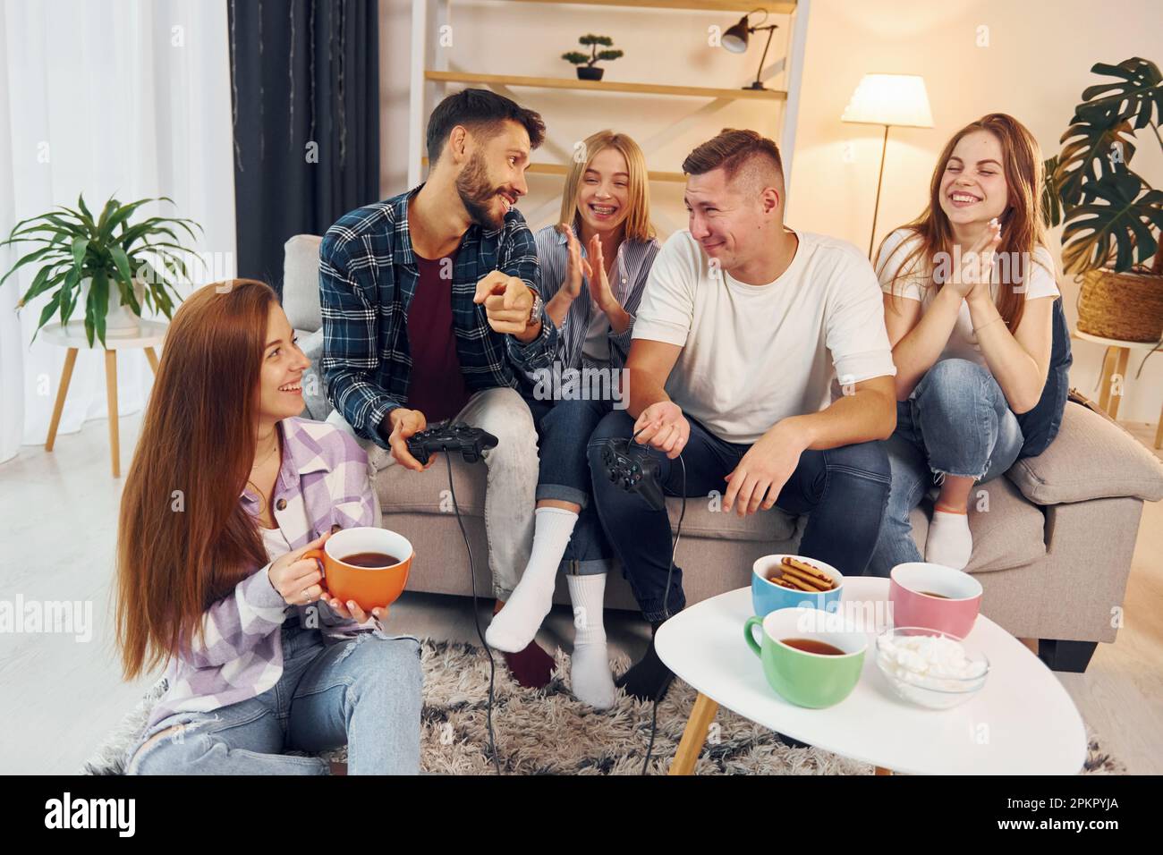 Spending weekend together. Group of friends have party indoors together ...