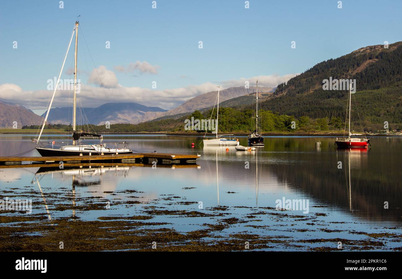 Sail boats on Loch Leven, reflecting in the Loch along with the ...