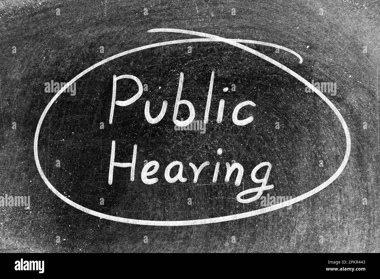White chalk hand writing in word public hearing and circle shape on ...