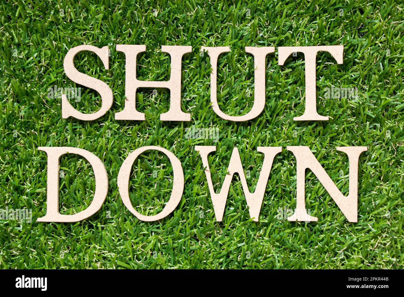 Wood alphabet letter in word shut down on artificial green grass ...