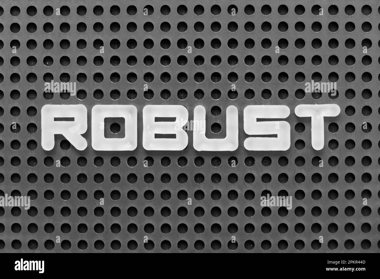 White alphabet letter in word robust on black pegboard background Stock ...
