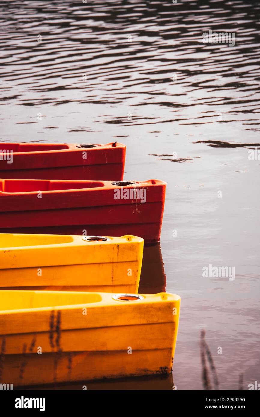 Four colourful boats on a lake Stock Photo - Alamy