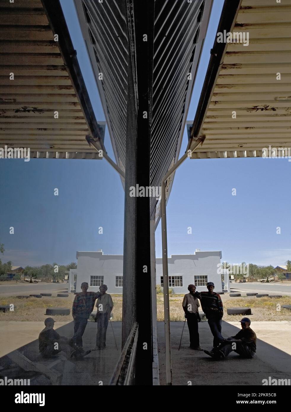 Locals are reflected in the showroom window of a garage in the Hantam ...