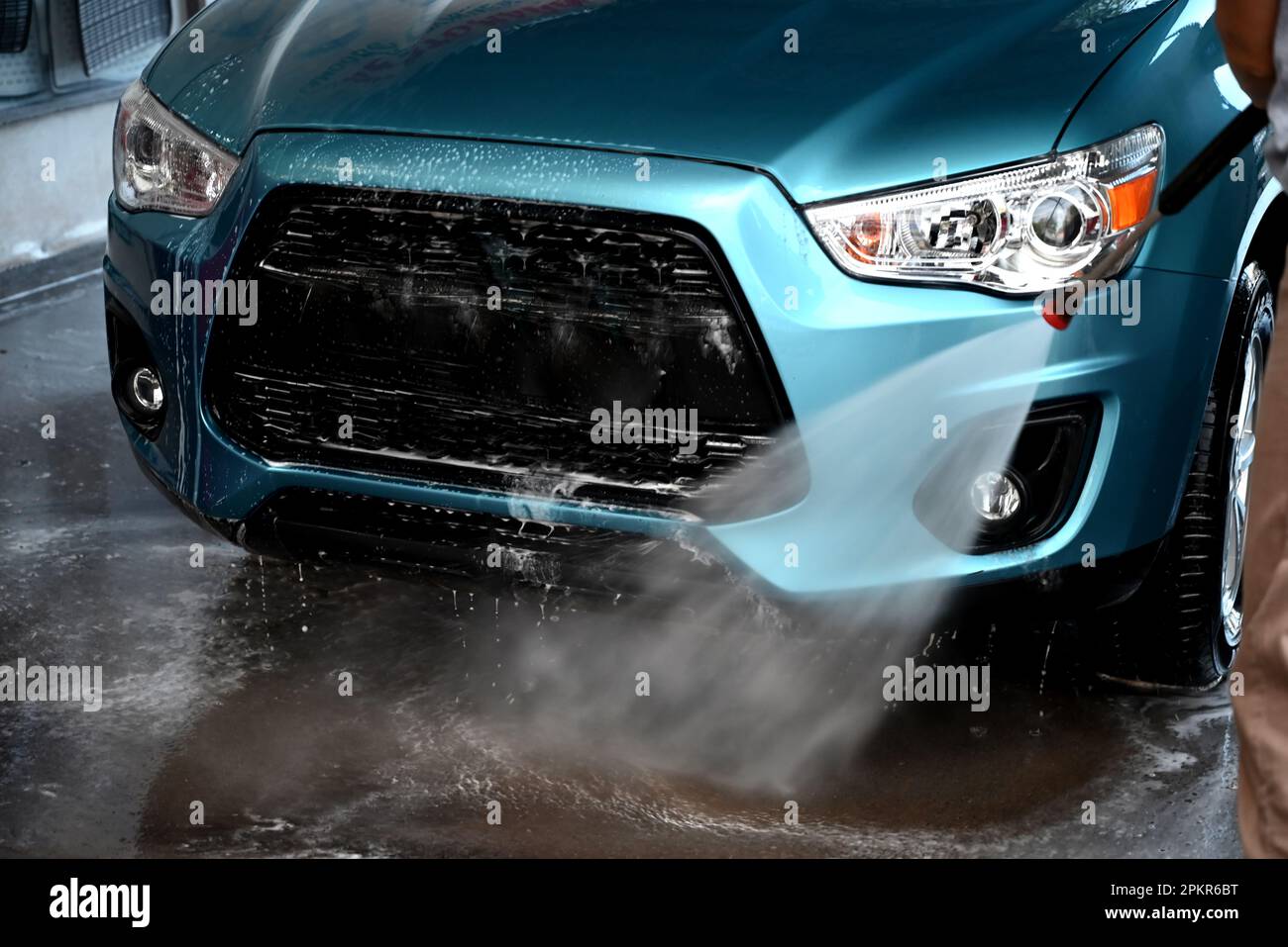 Cleaning car using active foam. Woman washing his car on self car ...