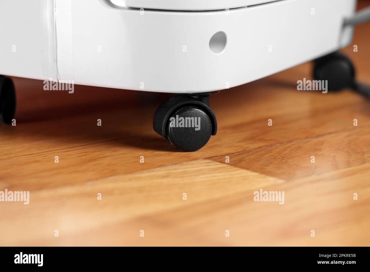 Plastic wheel of household electrical appliance on a laminate floor in ...