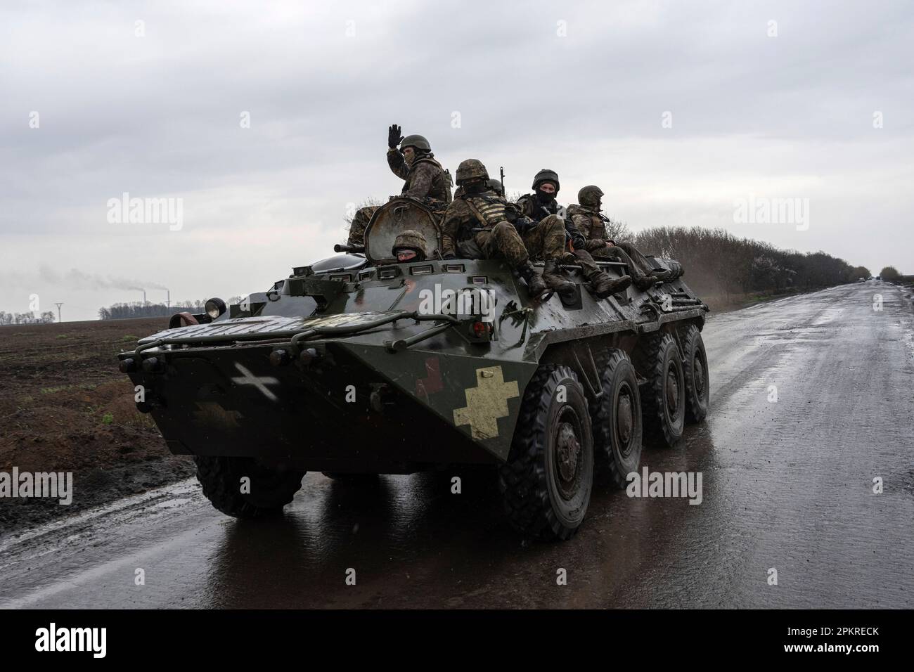 Ukrainian servicemen ride atop by an APC towards frontline positions ...