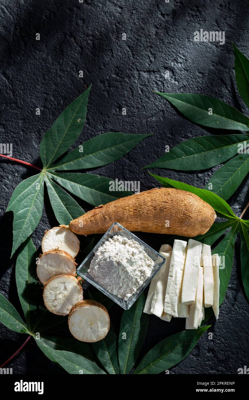pile of cassava fruit and cassava flour on a background of rustic and ...