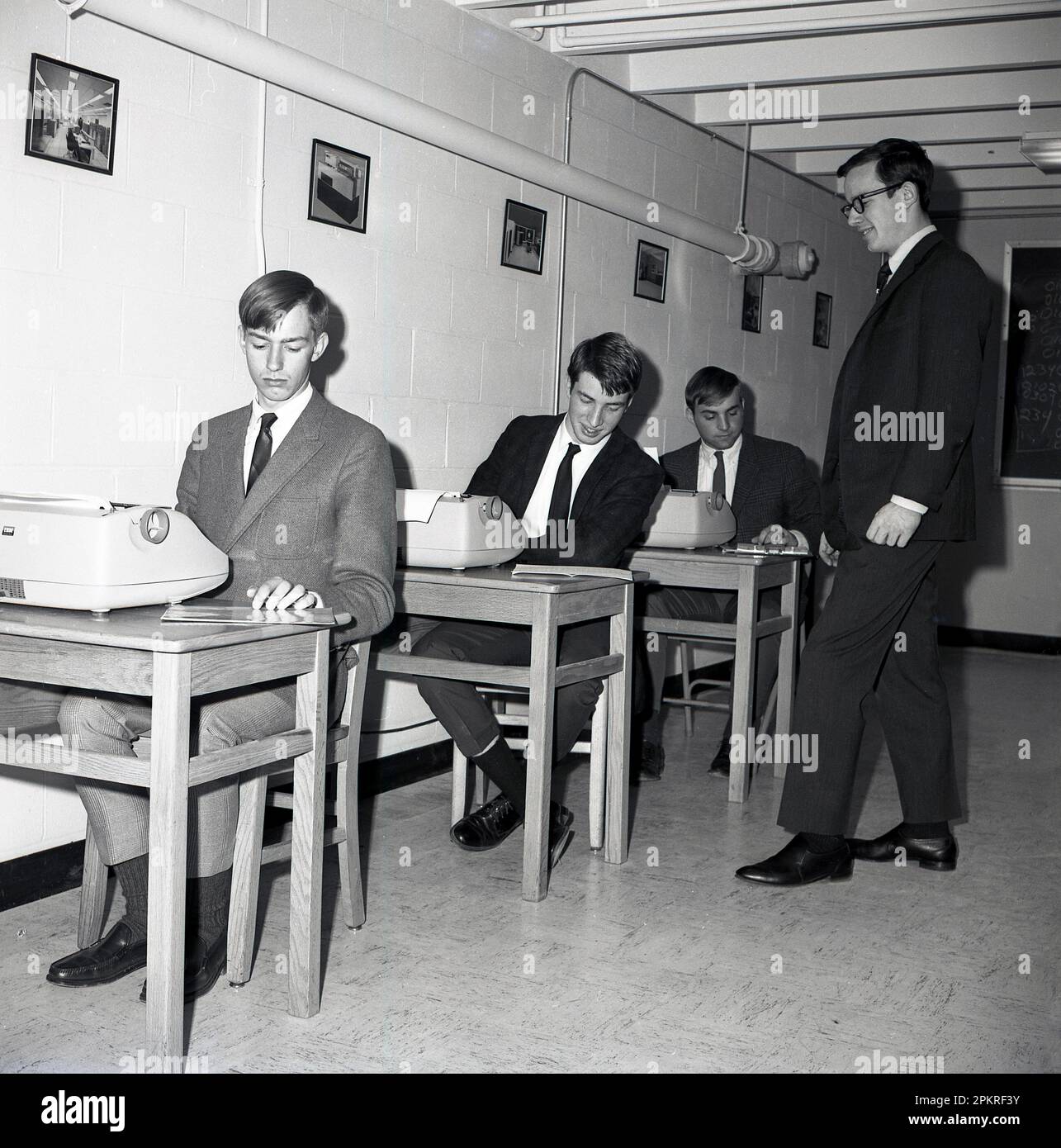 Students in typing class using electric typewriters at desks hi-res ...