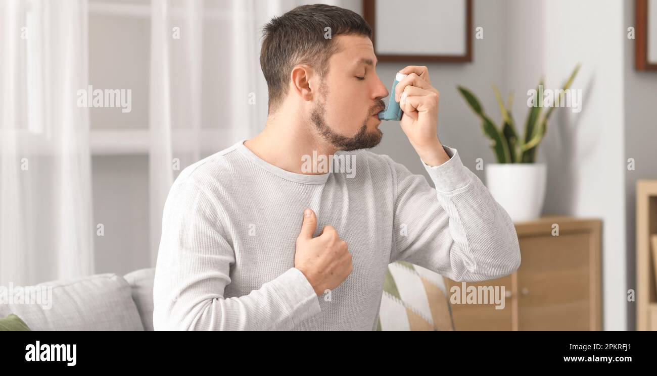 Sick man using inhaler at home Stock Photo - Alamy