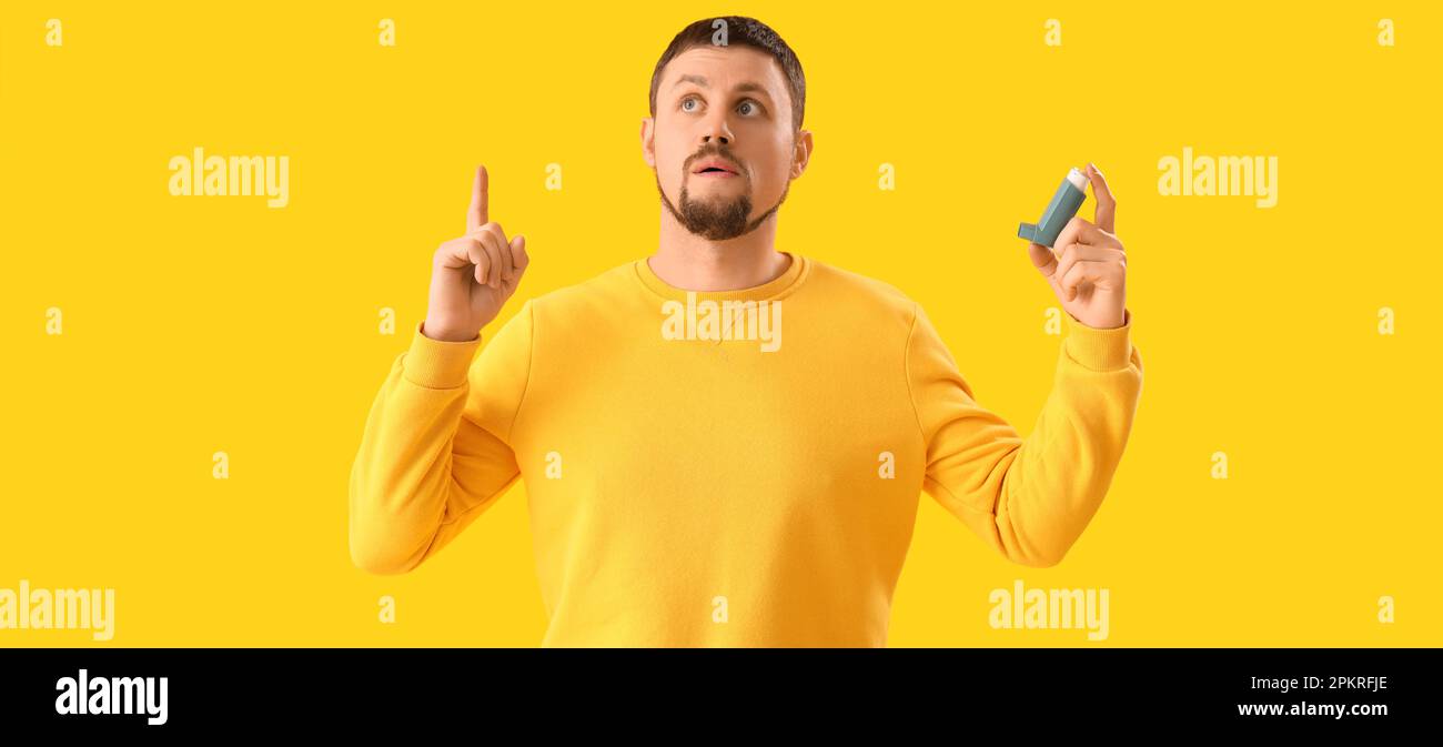 Man with inhaler and raised index finger on yellow background Stock ...