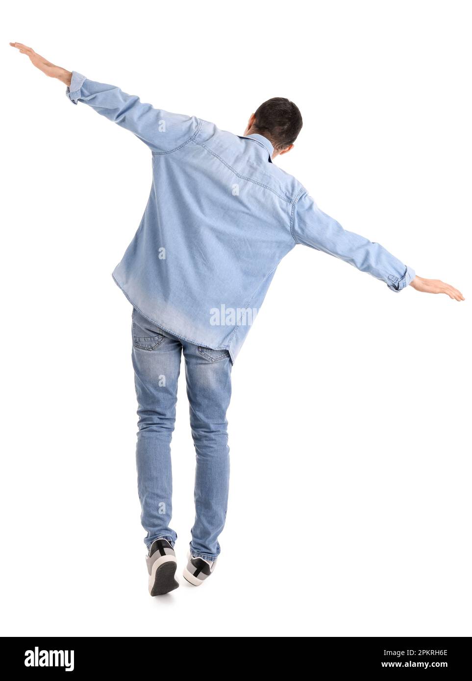 Young man balancing on white background, back view Stock Photo - Alamy