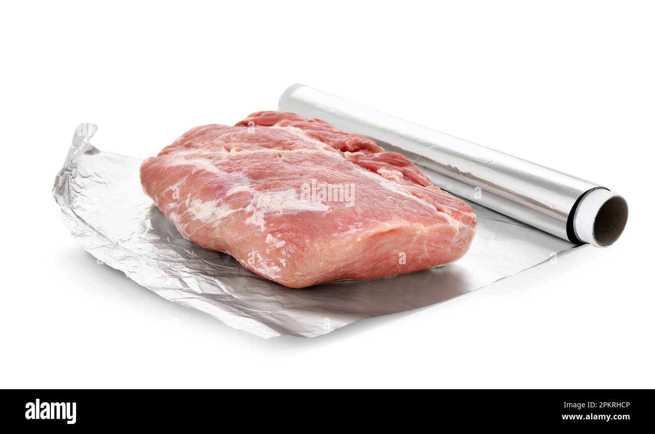 Aluminium foil roll with piece of raw meat on white background Stock ...