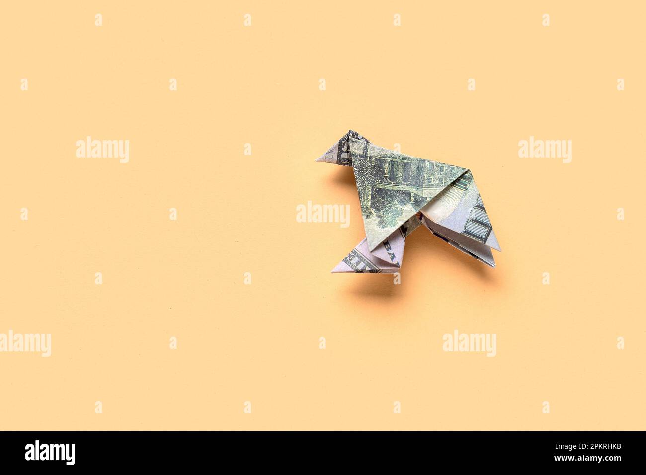 Origami bird made of dollar banknotes on beige background Stock Photo ...