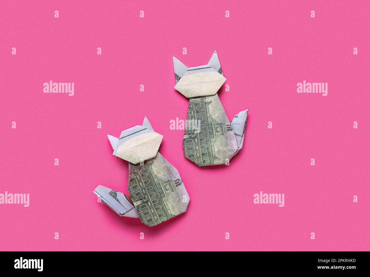 Origami cats made of dollar banknotes on pink background Stock Photo ...