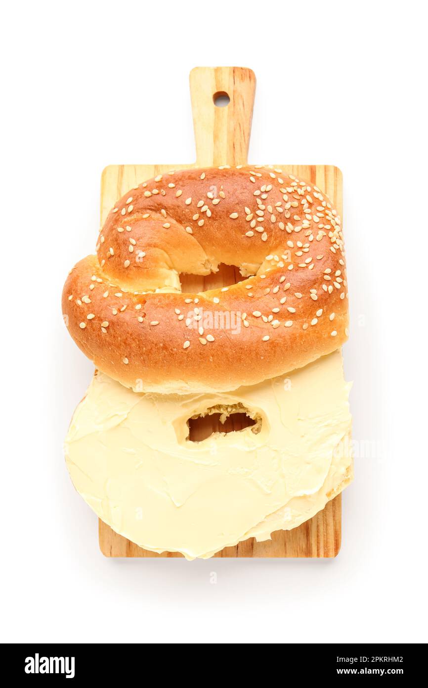 Wooden board of tasty bagel with cream cheese on white background Stock ...