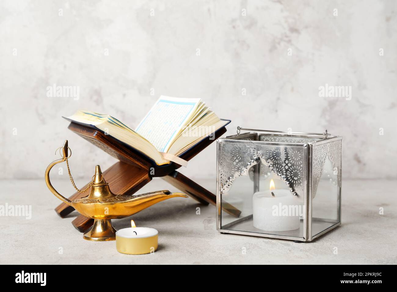 Muslim lantern with burning candles, Aladdin lamp and Koran on grunge ...