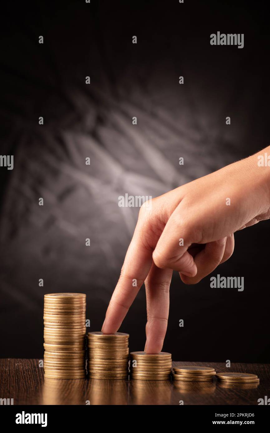 Finger stepping coin stack, profit making cocnept Stock Photo - Alamy
