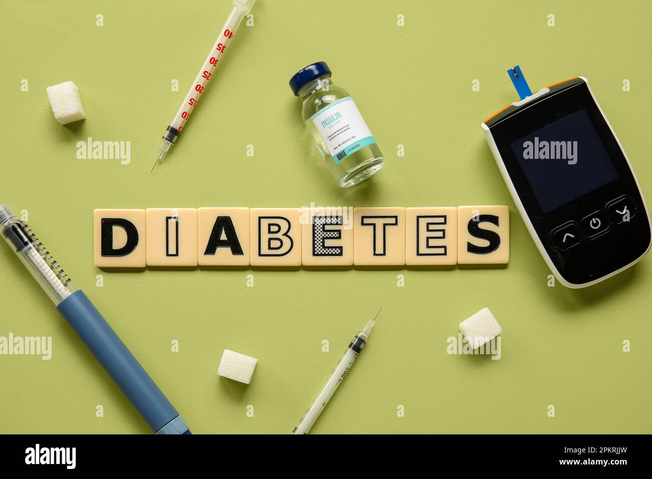 Word DIABETES with glucometer, insulin, lancet pen and sugar on green ...