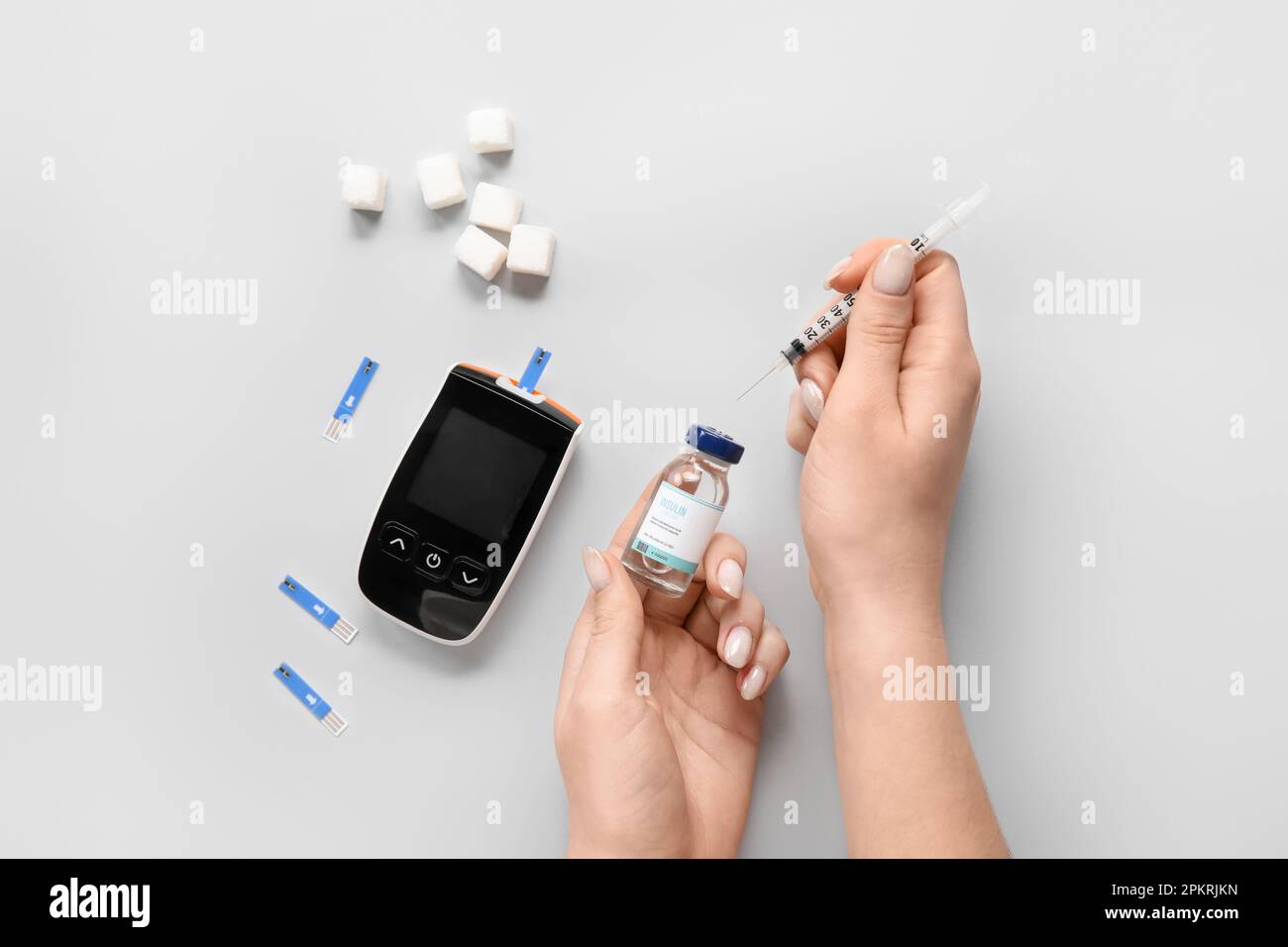 Woman with insulin and syringe on grey background. Diabetes concept ...