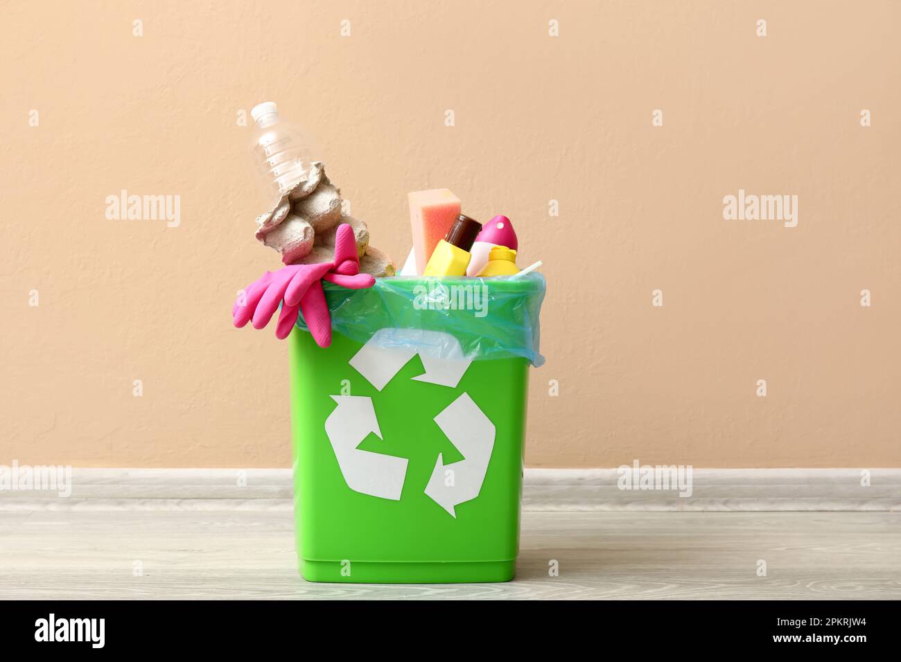 Recycling bin with garbage near beige wall Stock Photo - Alamy