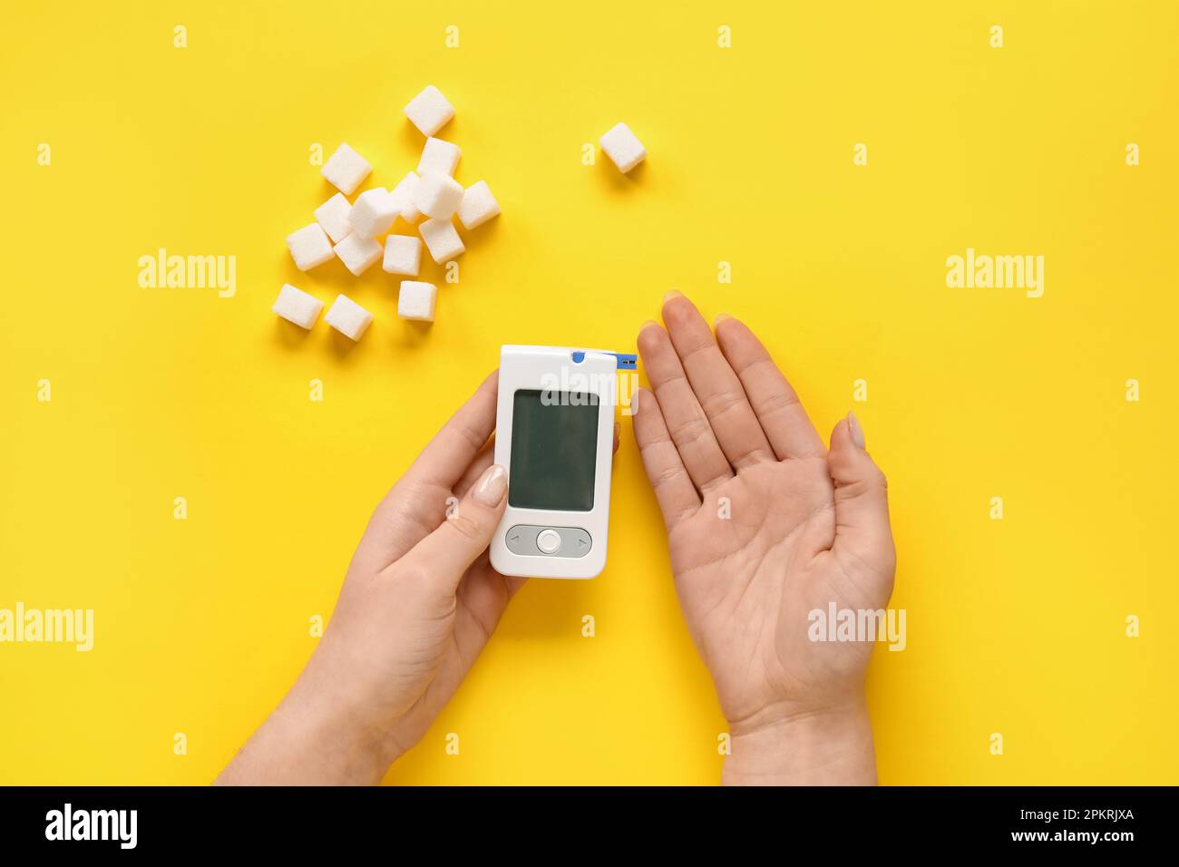Diabetic woman with glucometer and sugar on yellow background Stock ...
