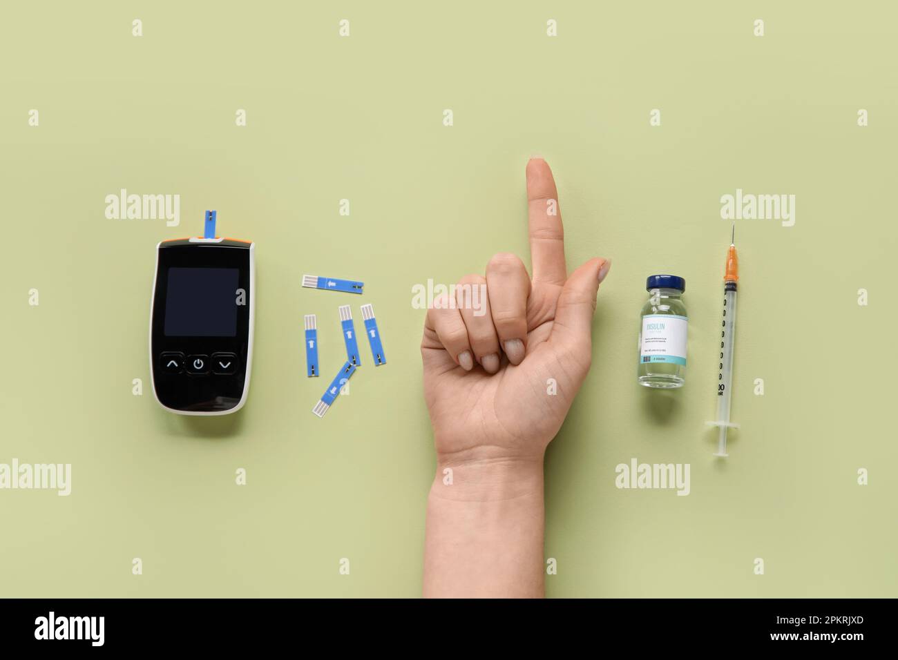 Diabetic woman with digital glucometer and insulin on green background ...