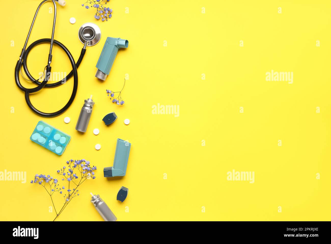 Asthma inhalers with stethoscope, pills and flowers on yellow ...
