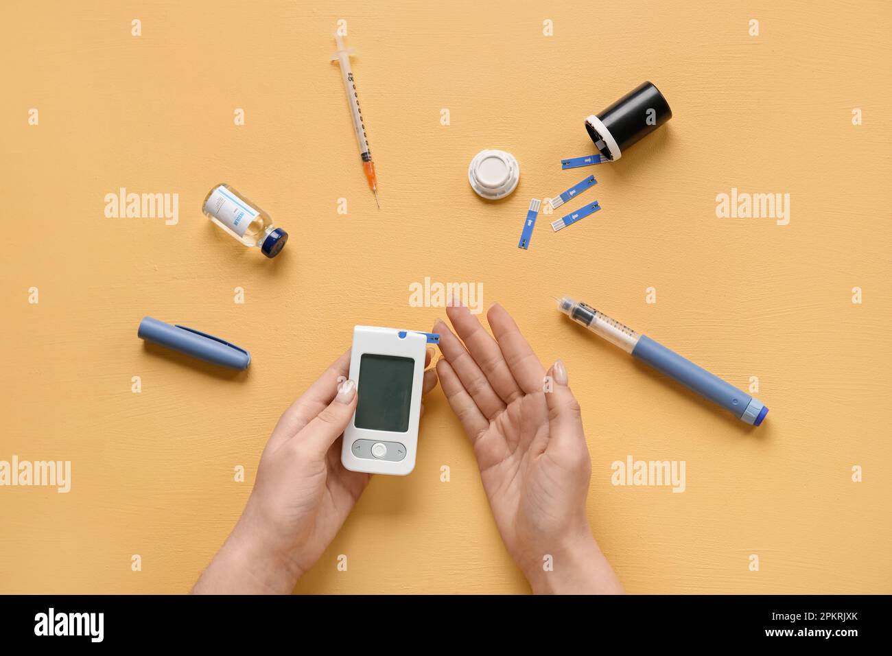Diabetic woman with digital glucometer, lancet pen and insulin on ...