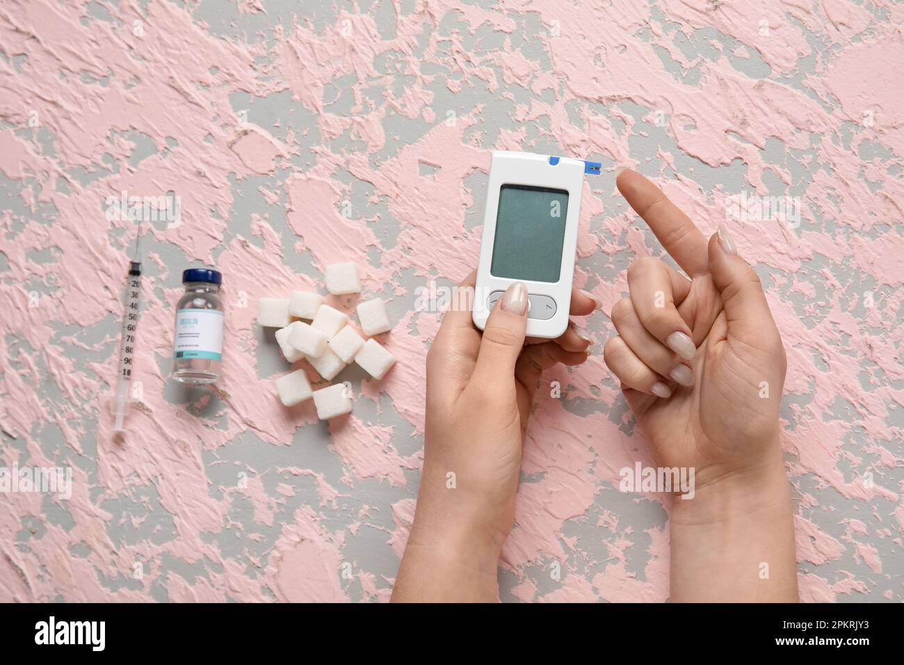 Diabetic woman using glucometer on grunge background Stock Photo - Alamy