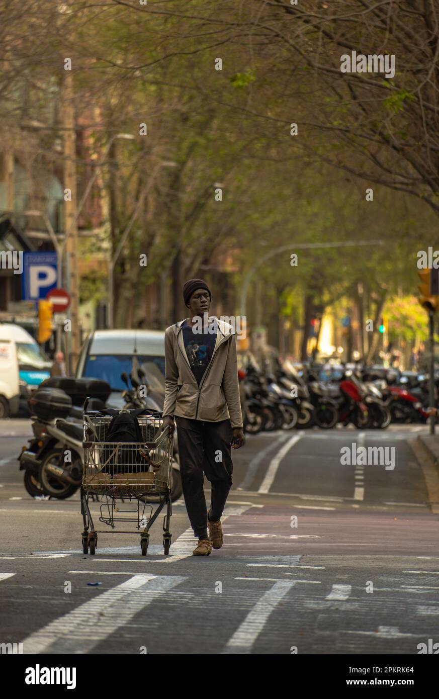 Black sub Saharan man with wool cap walking on the bike lane with his ...