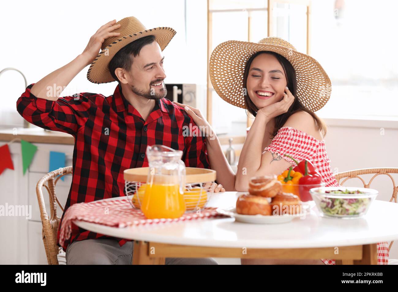 Young couple celebrating Festa Junina (June Festival) in kitchen Stock ...