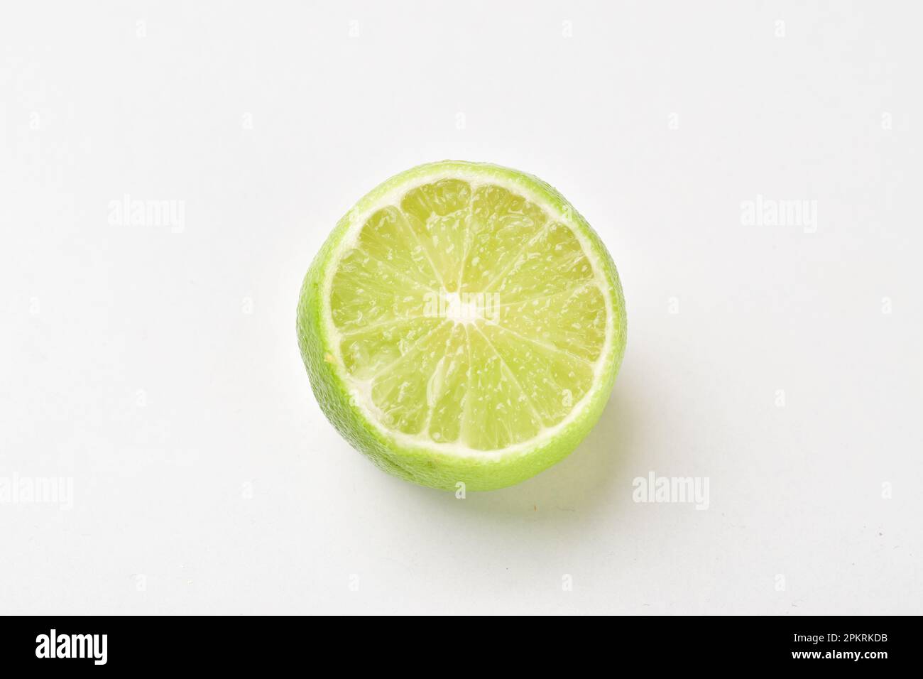 Green lemon slice on white background Stock Photo - Alamy