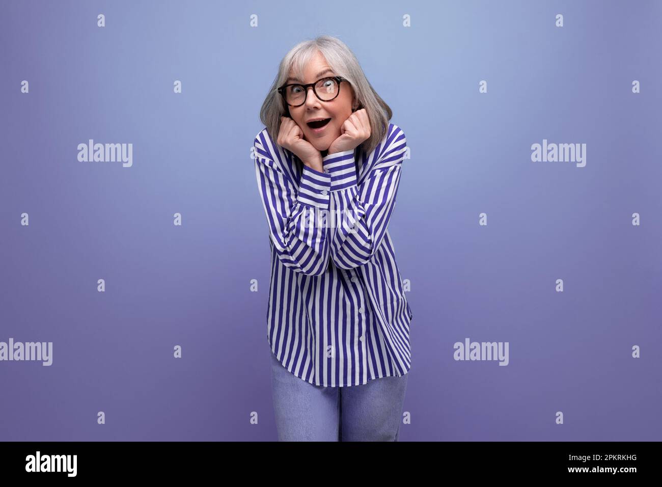 shocked mature old woman with gray hair on a bright studio background ...