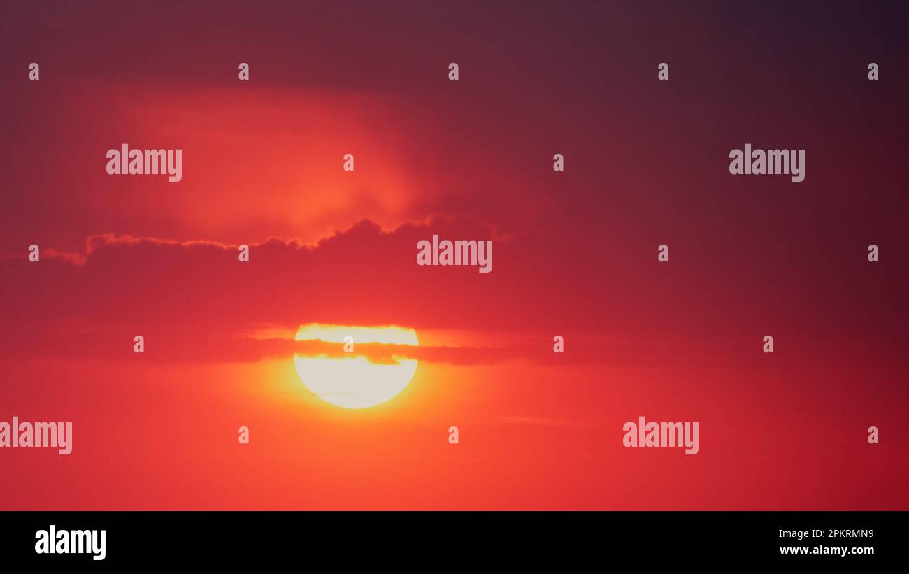 Sunset sky with red light of the setting sun. Evening clouds in the ...