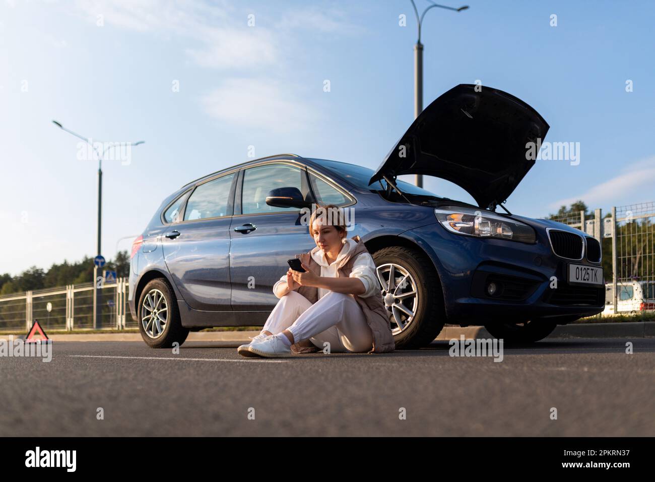 sad woman driver waiting for car repair service due to car breakdown on ...