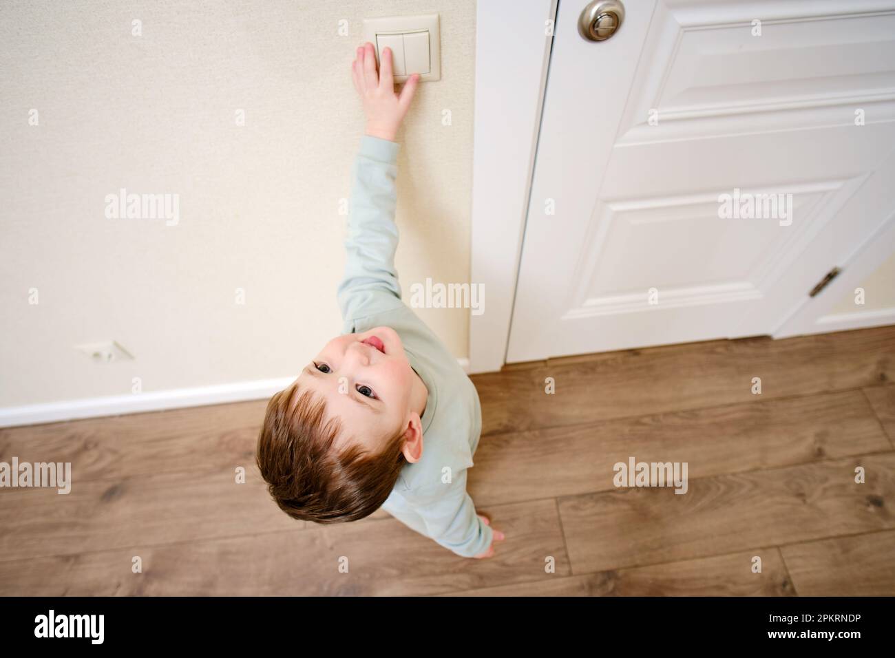 Little baby turns on the light by pressing the switch. Small child ...